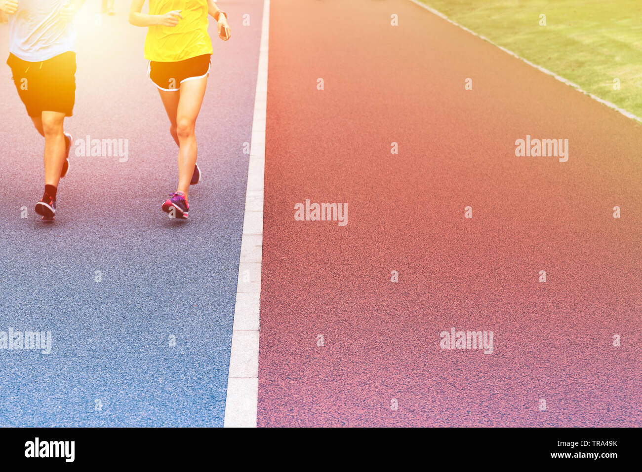 healthy woman and man running on path at public park, moving blurred ...