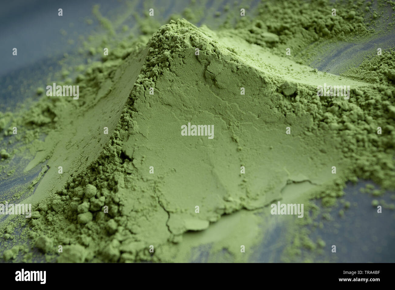 Close up pile of matcha powder on black plate. Natural matcha green tea ...