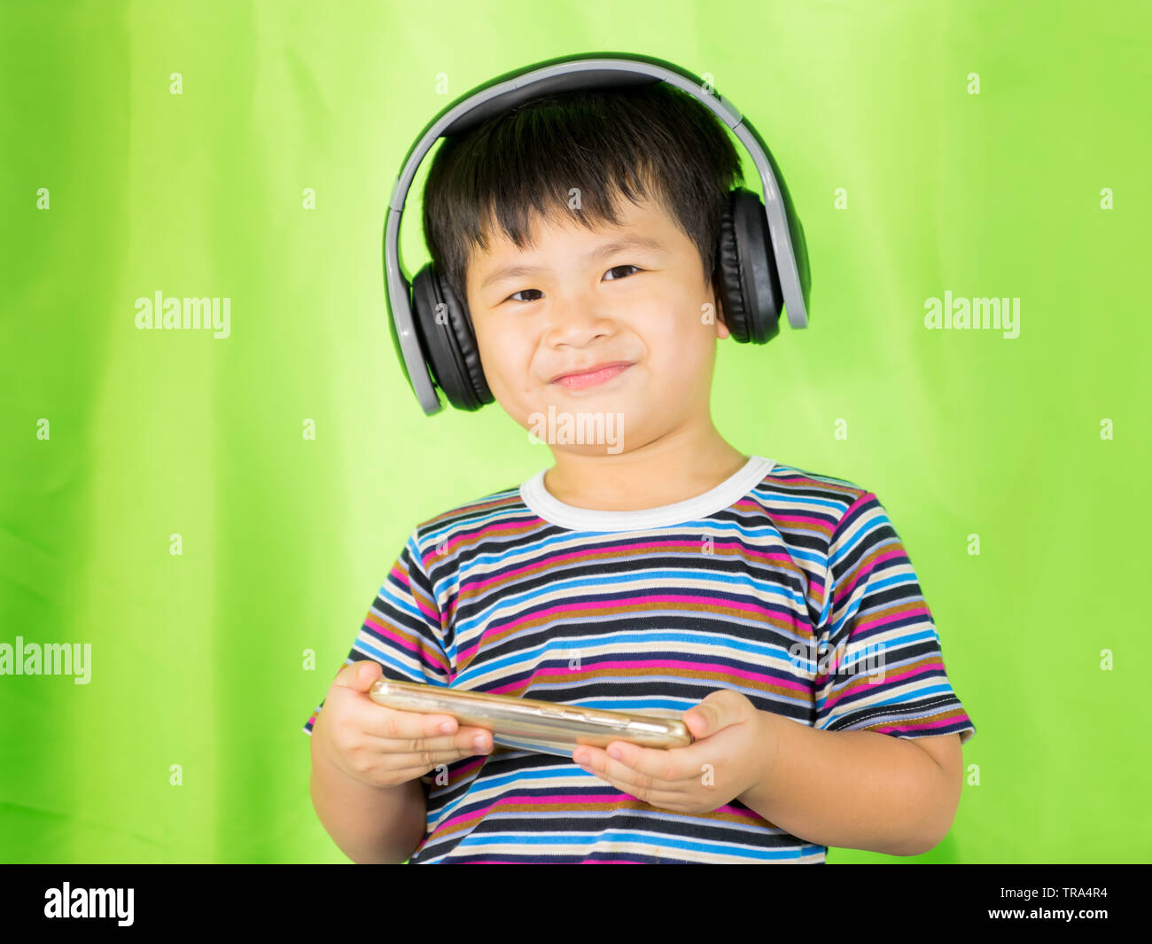 Asian cute boy listen music by telephone on green background Stock ...