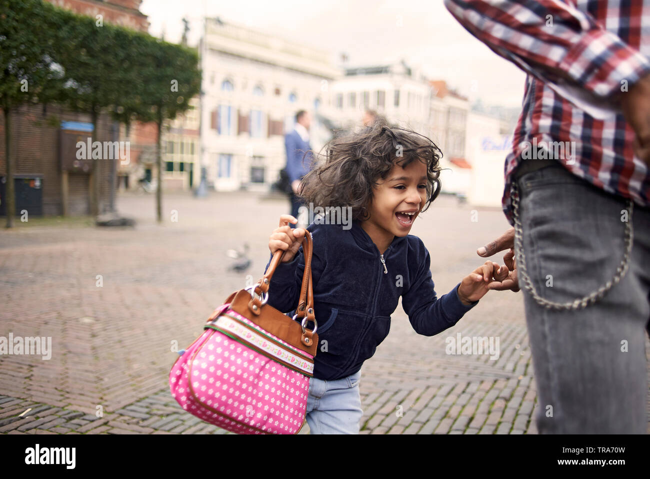 A cute young little black girl running around her father playing ...