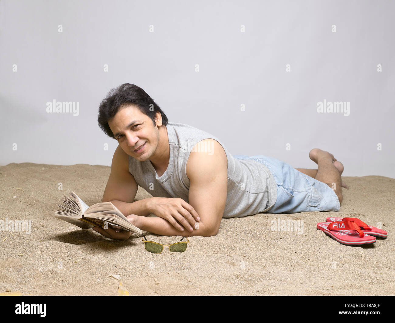 Man sunbathing reading book hi-res stock photography and images - Alamy