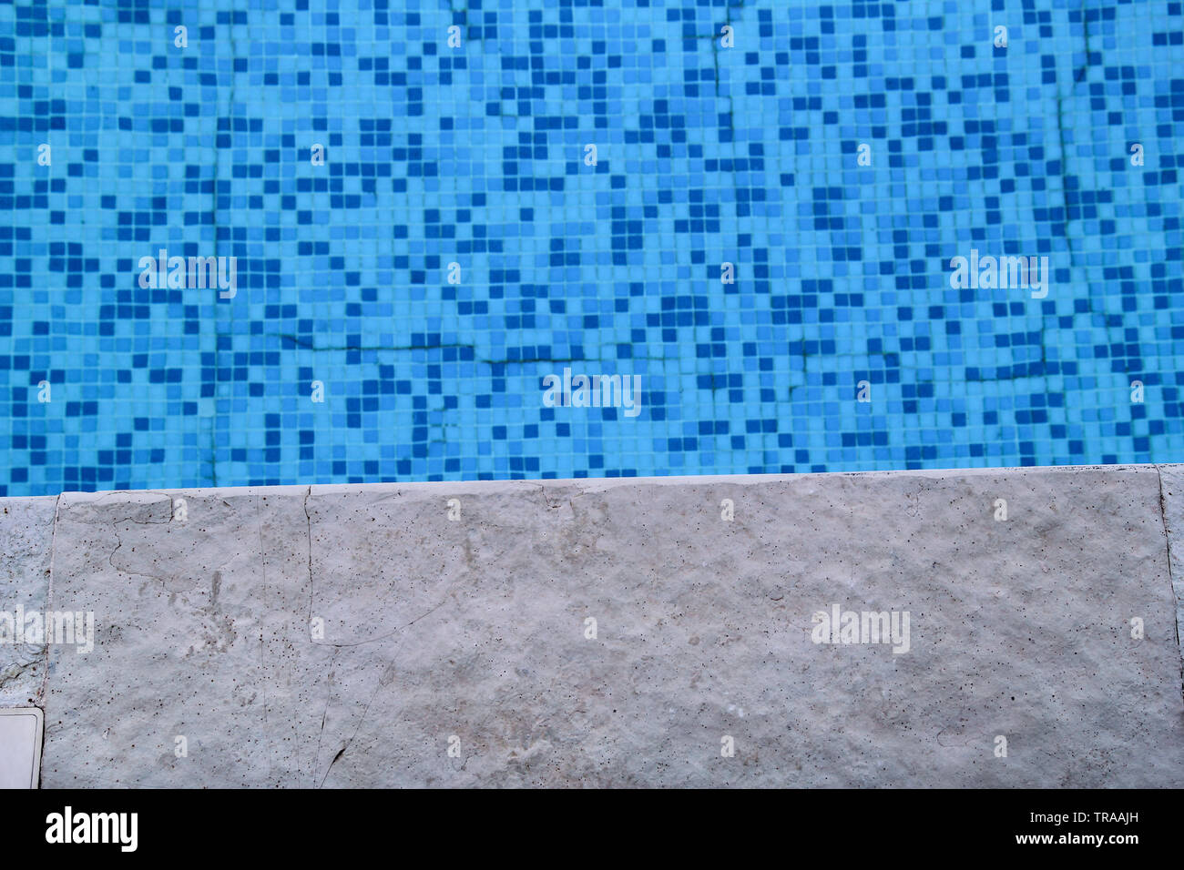 Blue ripped water in swimming pool in tropical resort with edge of ...