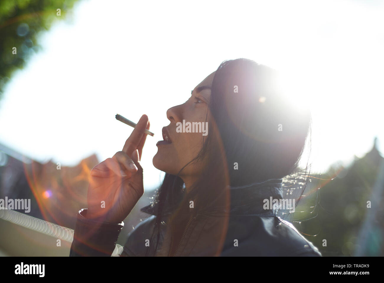 Asian tourist enjoying smoking a spliff with marijuana in summer ...