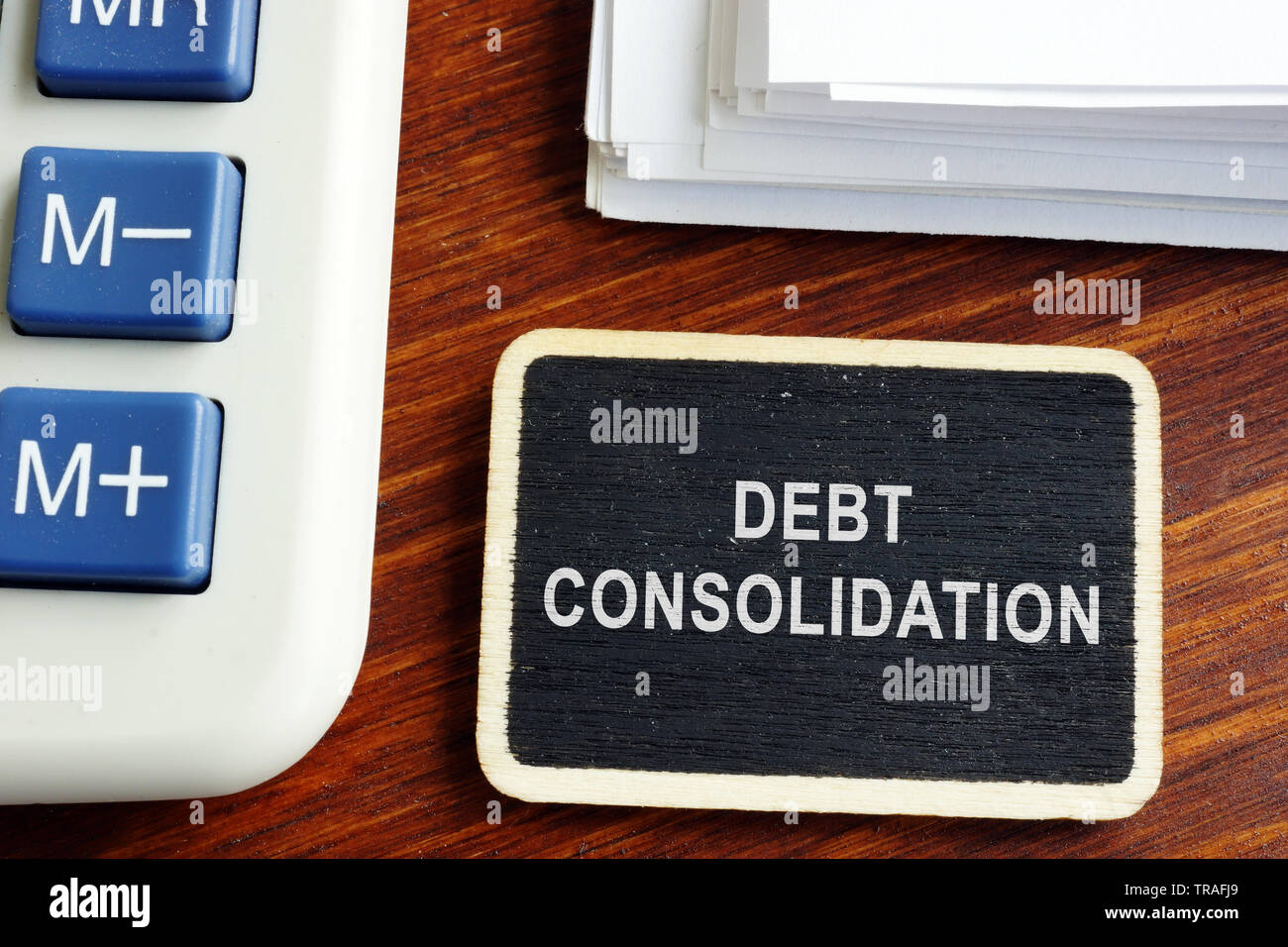 Debt consolidation loan. Nameplate with stack of documents Stock Photo ...