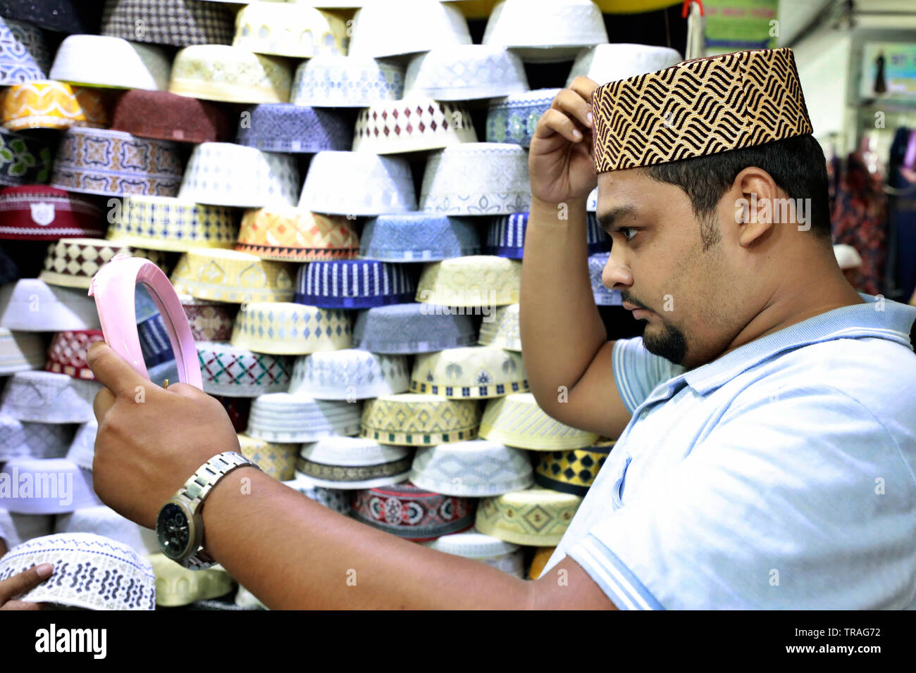 Dhaka, Bangladesh - June 01, 2019: A customer trying a tupi or prayer ...
