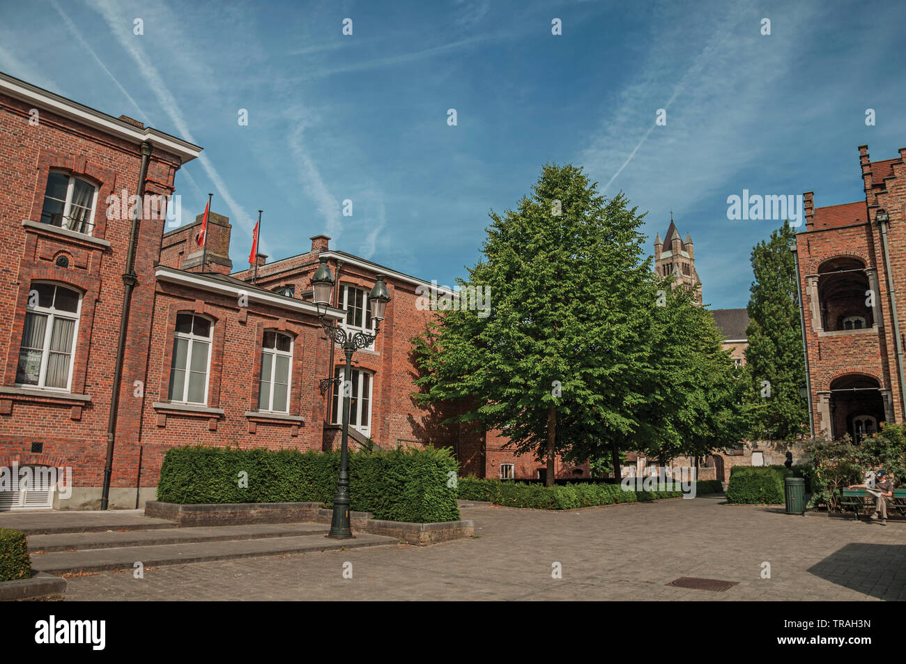 Peaceful courtyard, trees and old brick buildings in Bruges. Charming ...