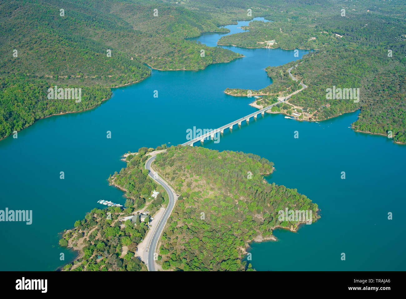 AERIAL VIEW. Reservoir surrounded by a landscape of dense vegetation in ...