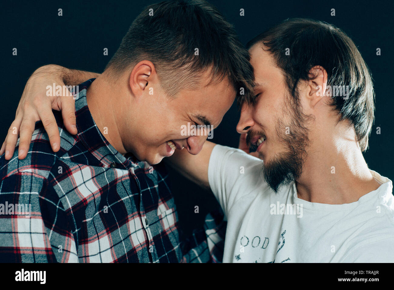 two guys hugging on a dark background Stock Photo - Alamy