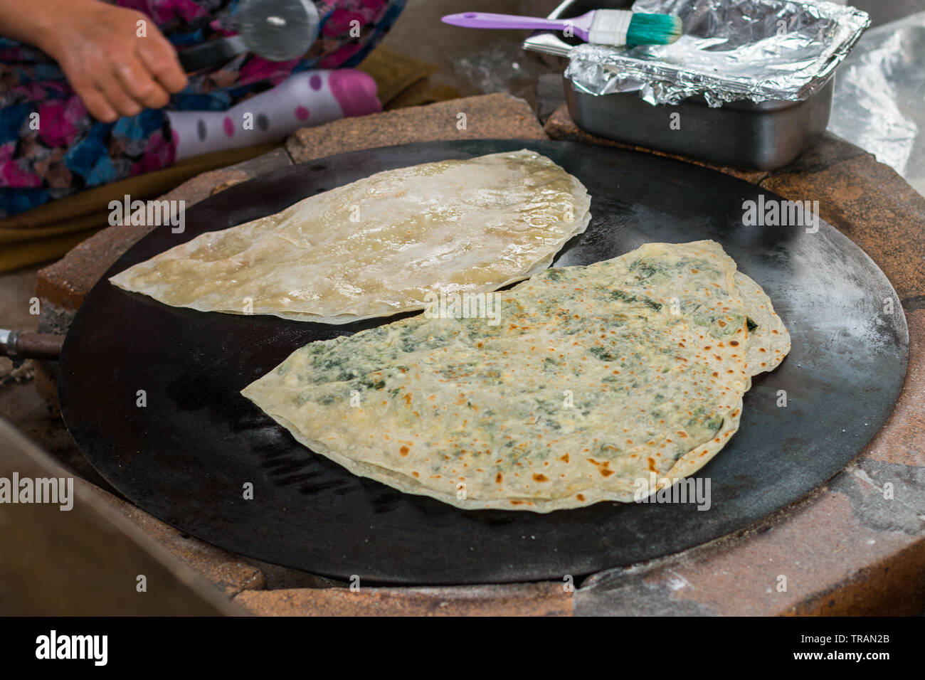 Turkish woman prepares Gozleme - traditional dish in the form of ...