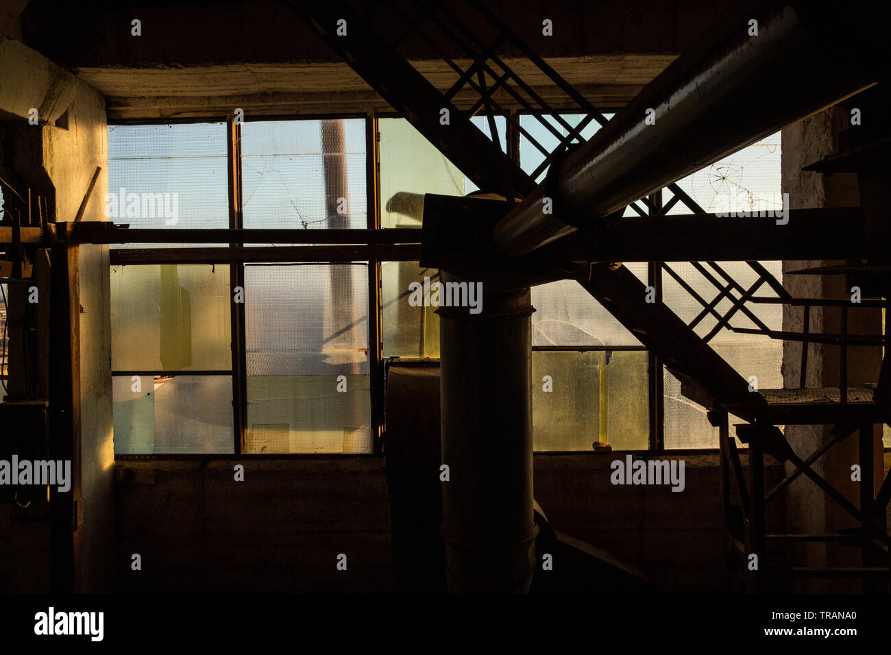 Pipes, stairs and colored window glass in an abandoned soviet era ...