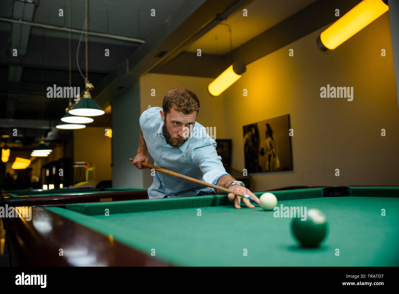 Young handsome man with beard plays billiards Stock Photo - Alamy