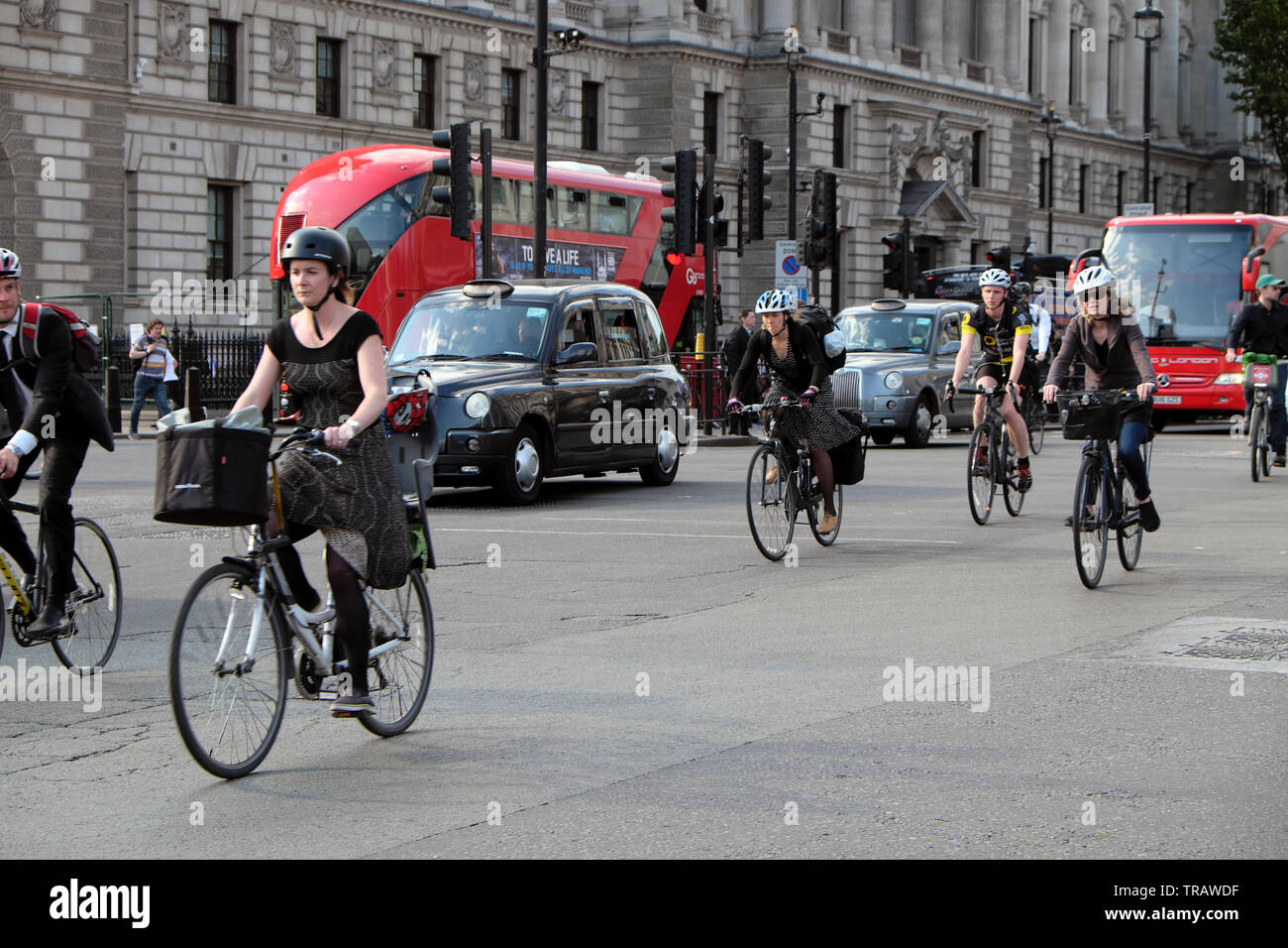 Office workers cycling home from work ride bikes through traffic ...