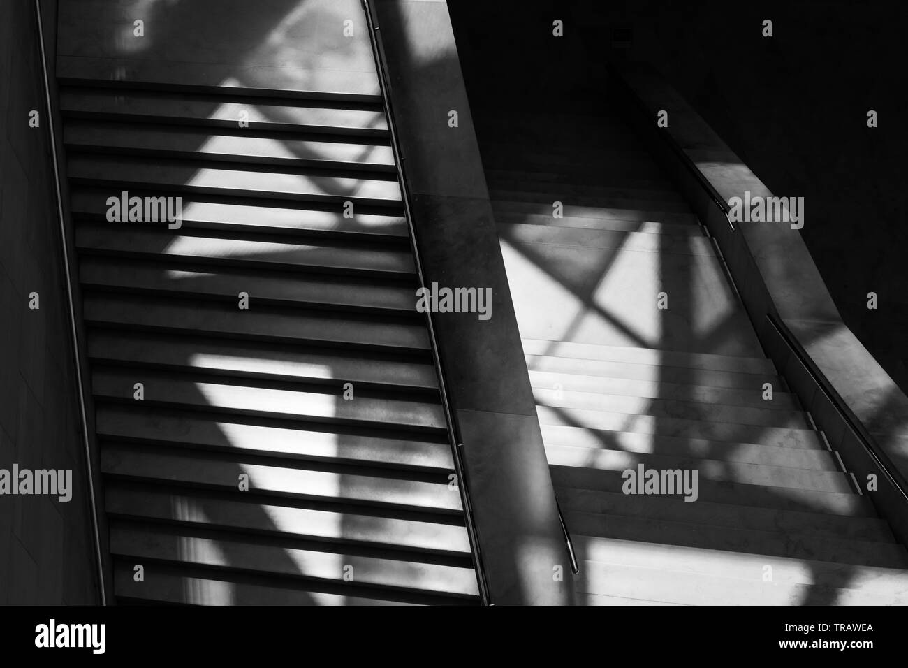 A stairwell has a dramatic patterned shadow cast on it, featuring ...