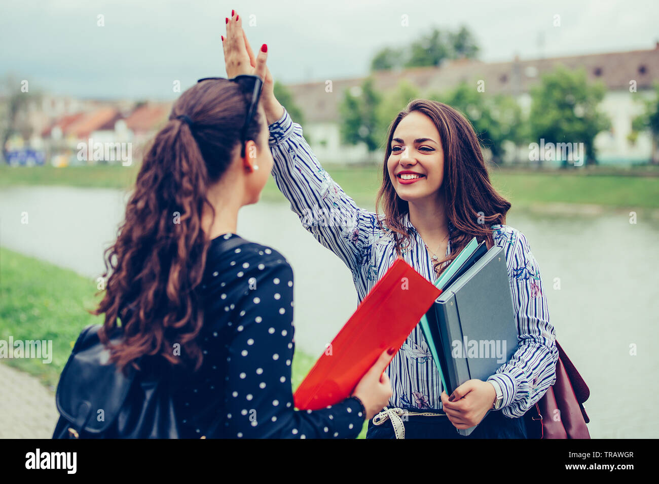 Two happy female students are giving high, celebrating success for ...