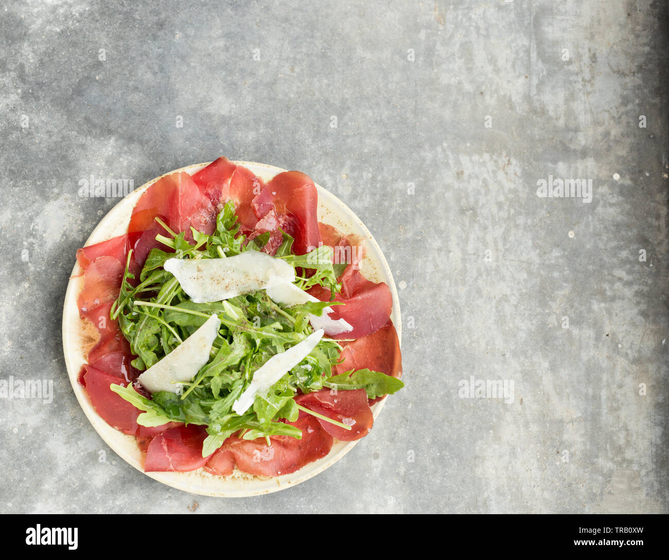 Bresaola, rocket and parmesan salad on a concrete table Stock Photo - Alamy
