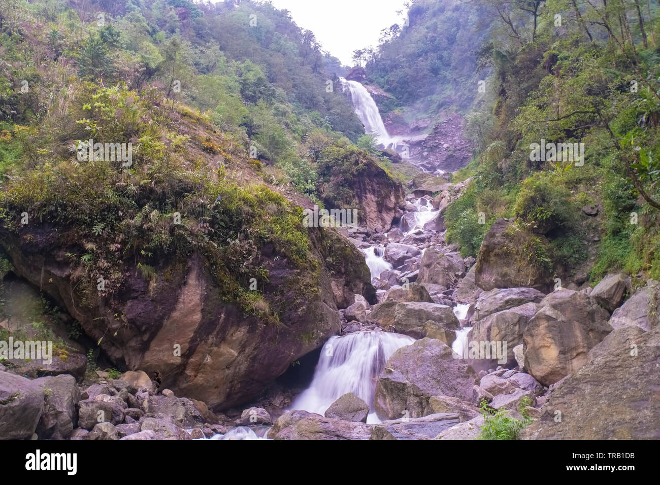 Naga waterfalls, in high,velocity, over huge ,rocks, cutting,down hills ...