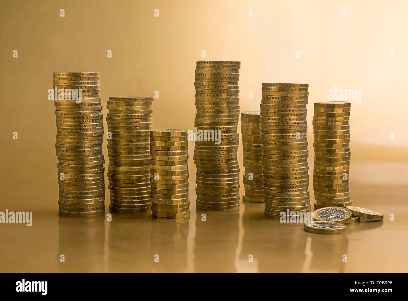 Stacked piles of one pound and two pound gold-colored coins Stock Photo ...