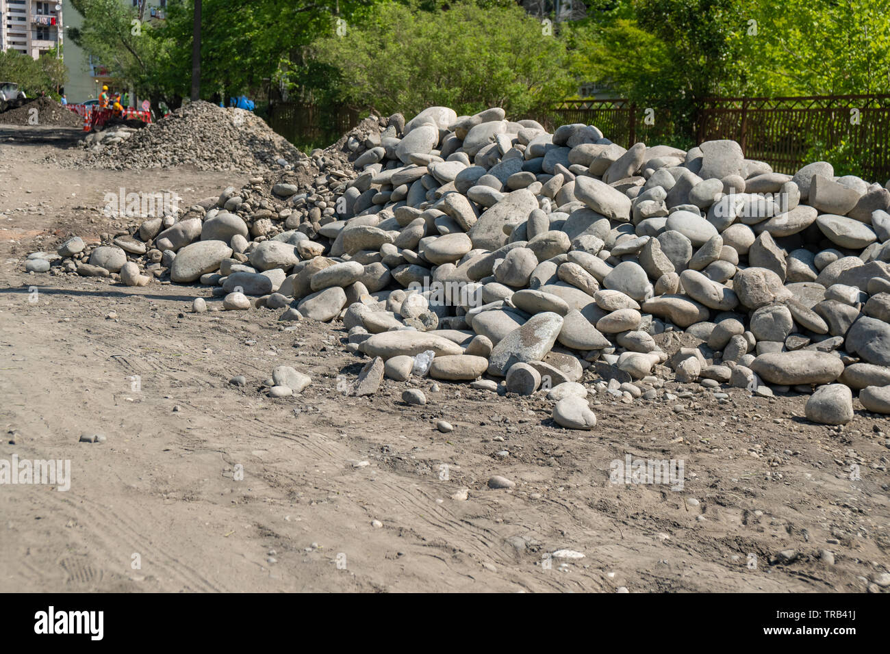 pile of rounded stones piled in the side of the road. stones for road ...
