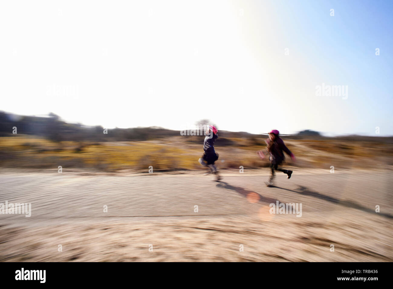 Two young girls running down a path in summer sunshine having fun Stock ...