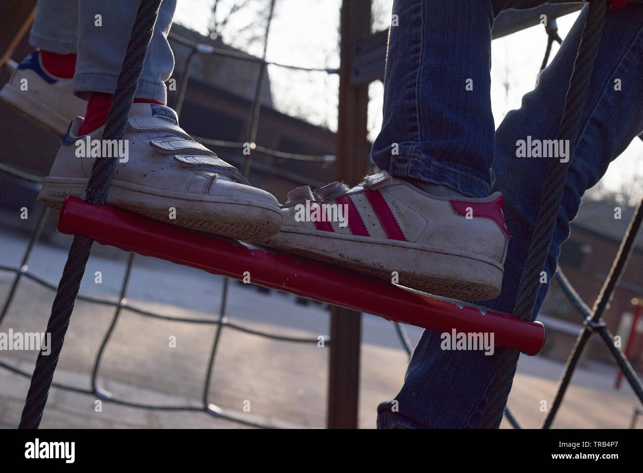 Close up of the legs of young children climbing up on a rack at a ...