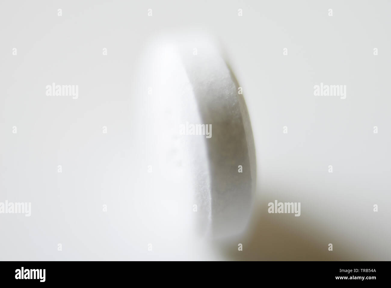 Extreme close up of a white pill on a white background Stock Photo - Alamy