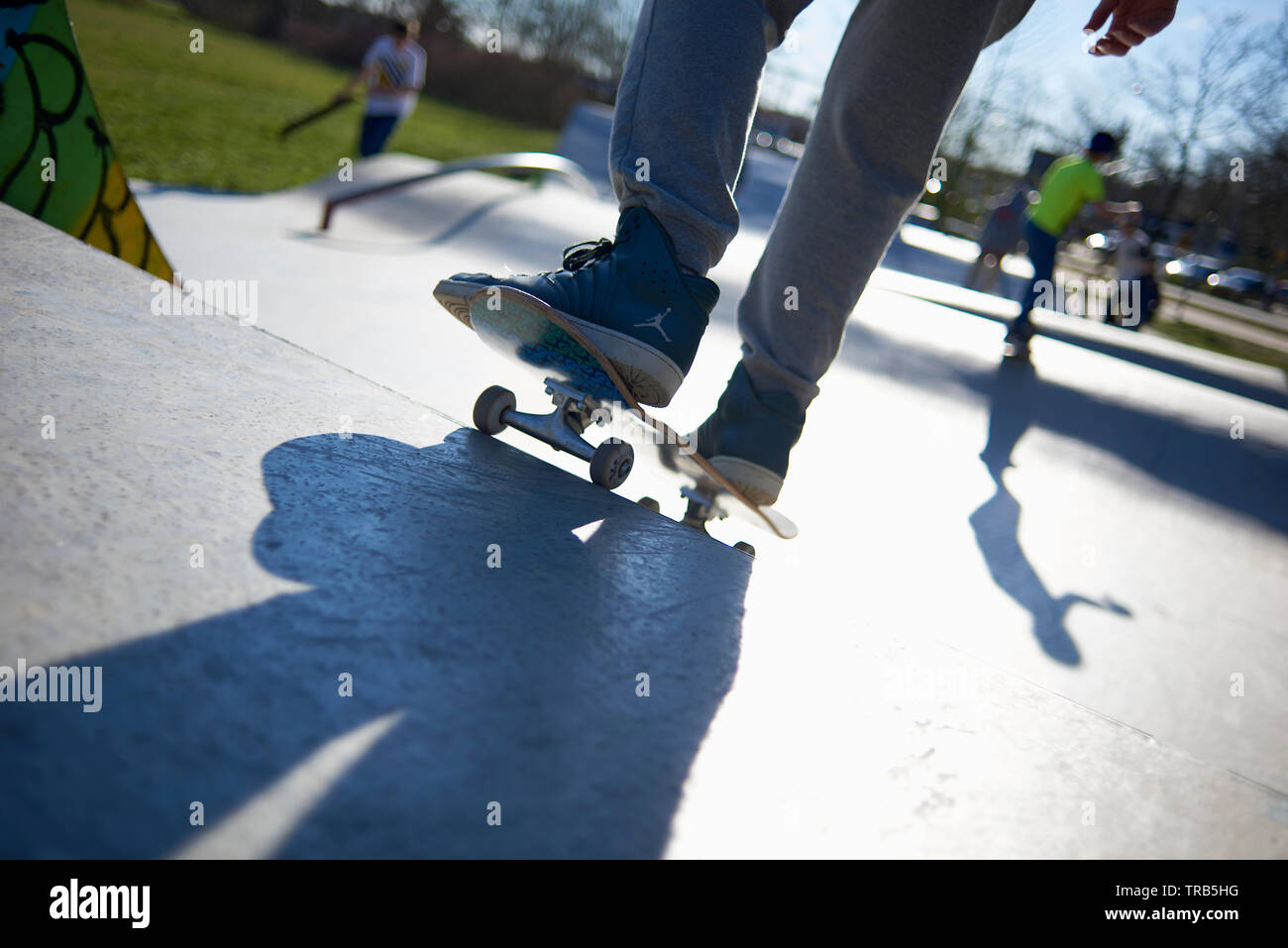 Close up of a young girl on a skateboard going down a ramp in spring ...
