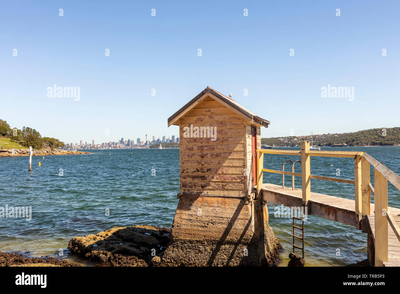 Vintage beach hut with peeling paint and small jetty on Camp Cove beach ...