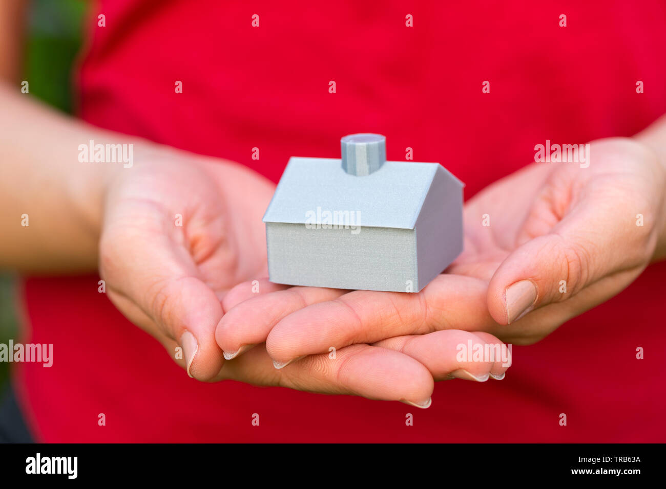 Close up picture of 3d printed house in female hands , new investments ...