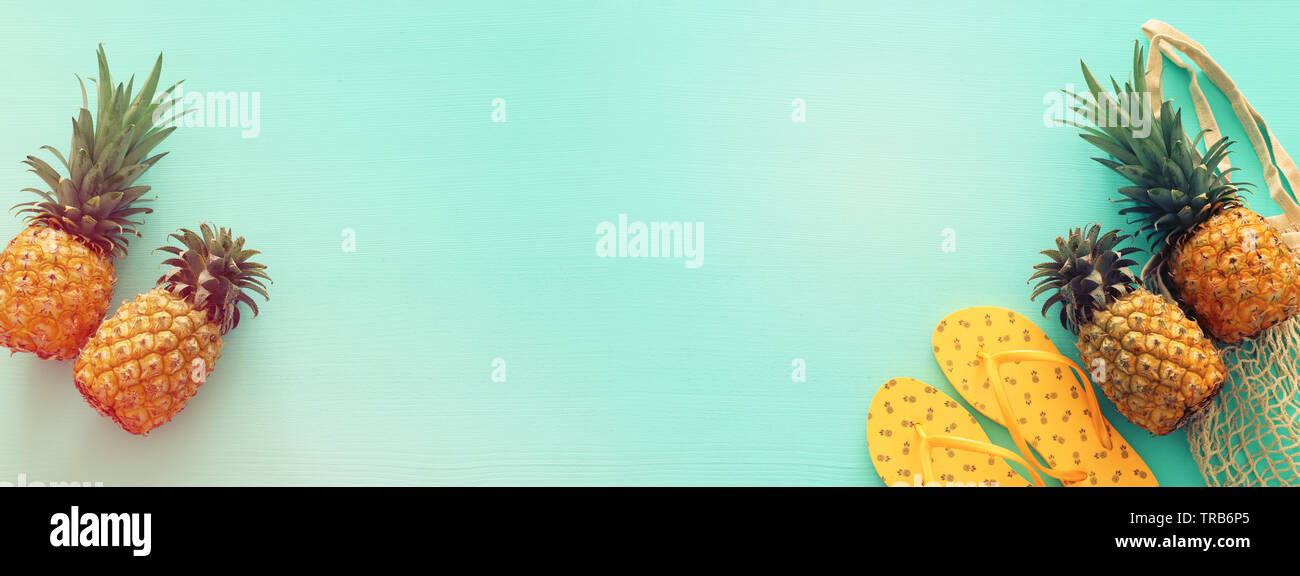 Ripe pineapple and beach sea life style objects over pastel mint blue ...