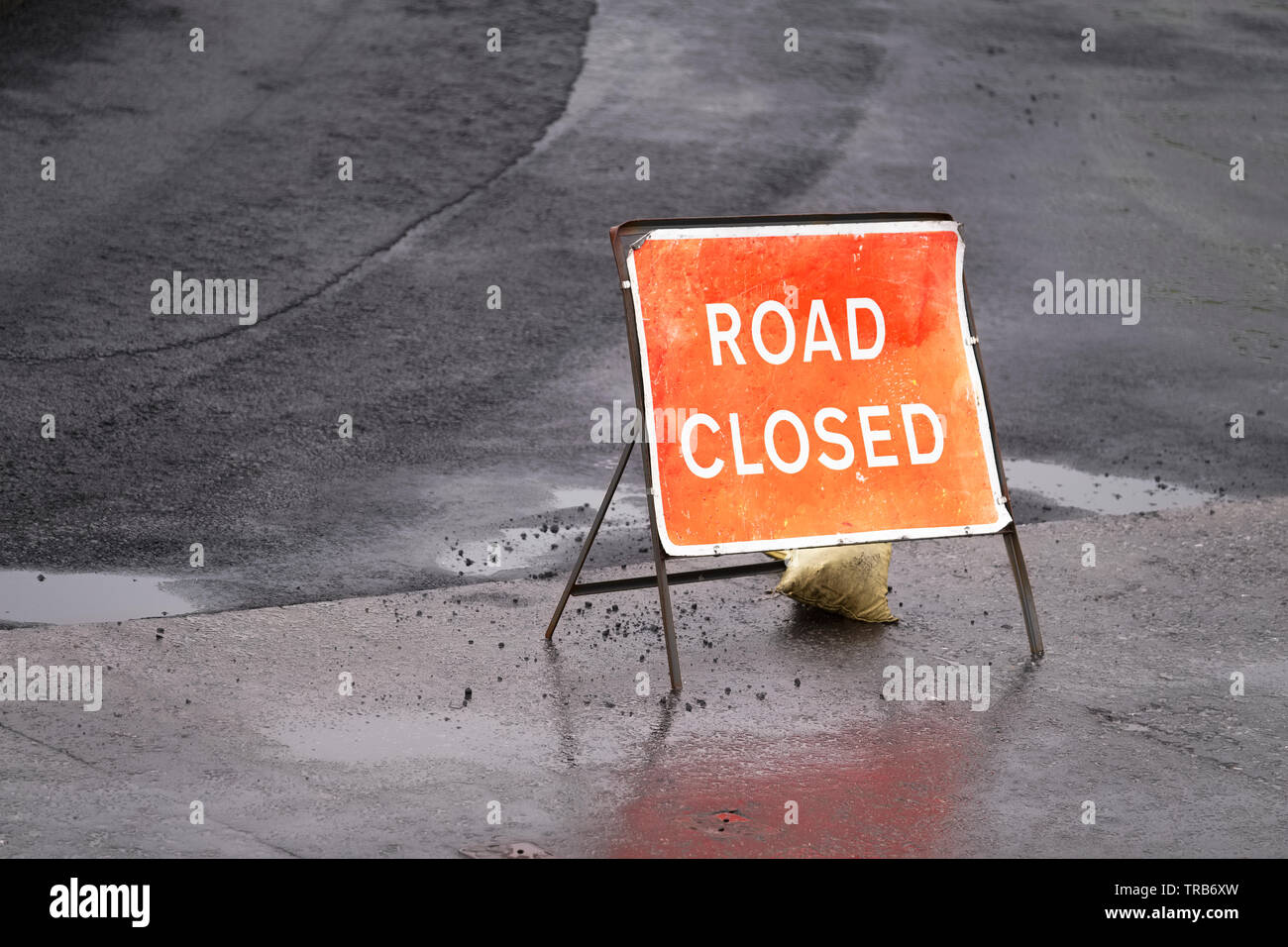 Road closed red sign and black tar asphalt street Stock Photo - Alamy
