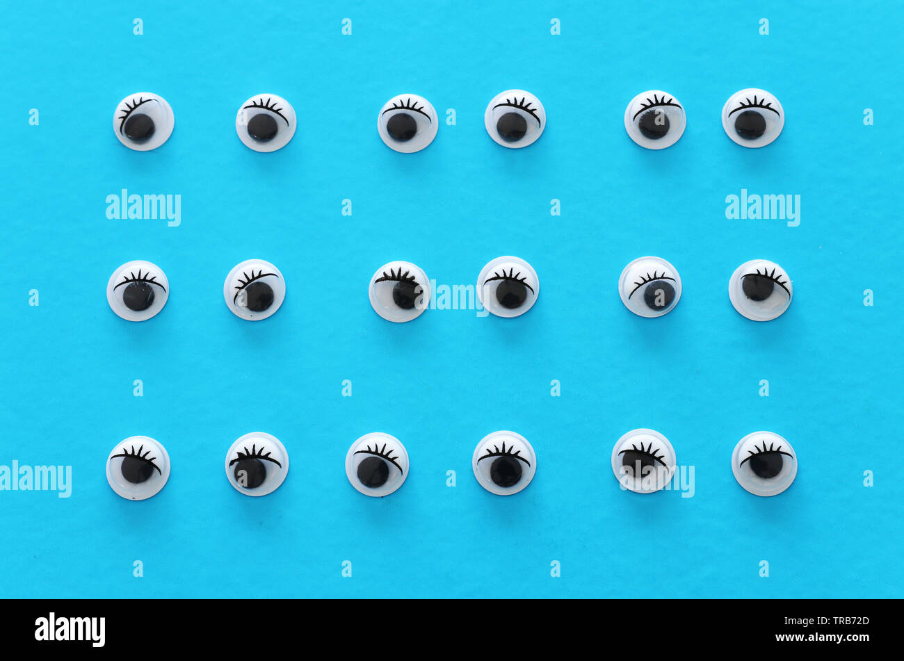 many googly eyes over blue background Stock Photo - Alamy