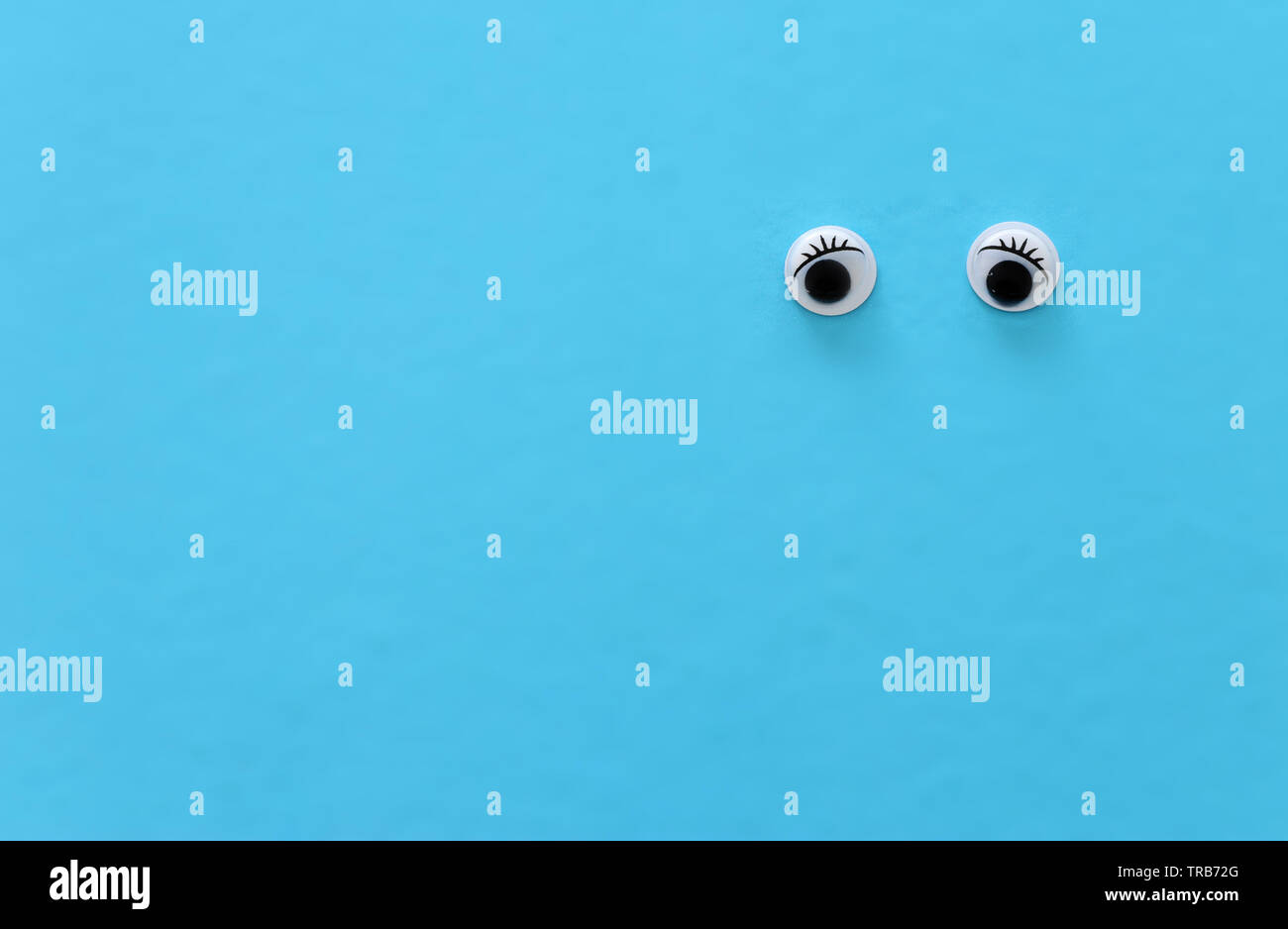 pair googly eyes over blue background Stock Photo - Alamy