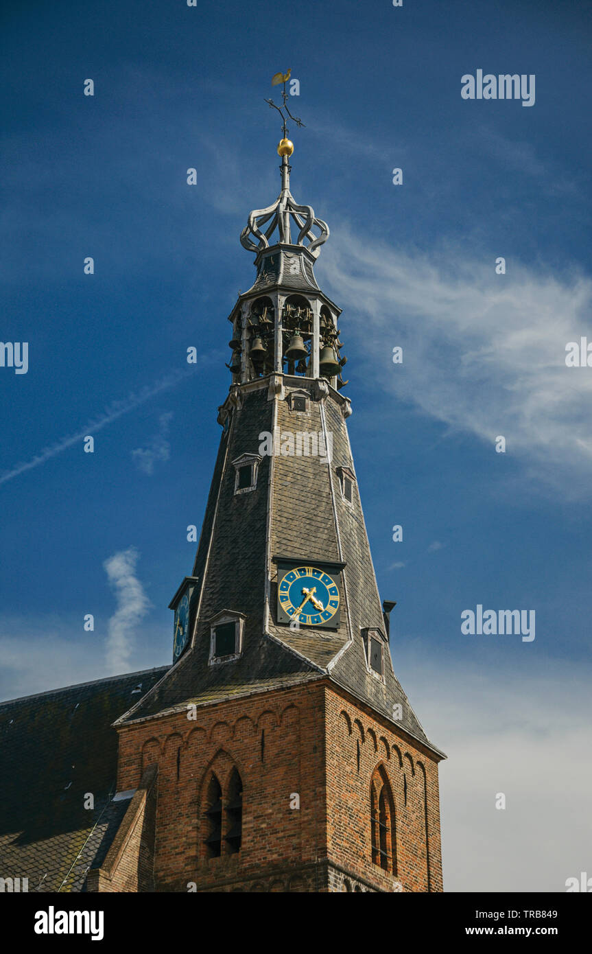 Church tower with a pointed roof and golden clock hi-res stock ...