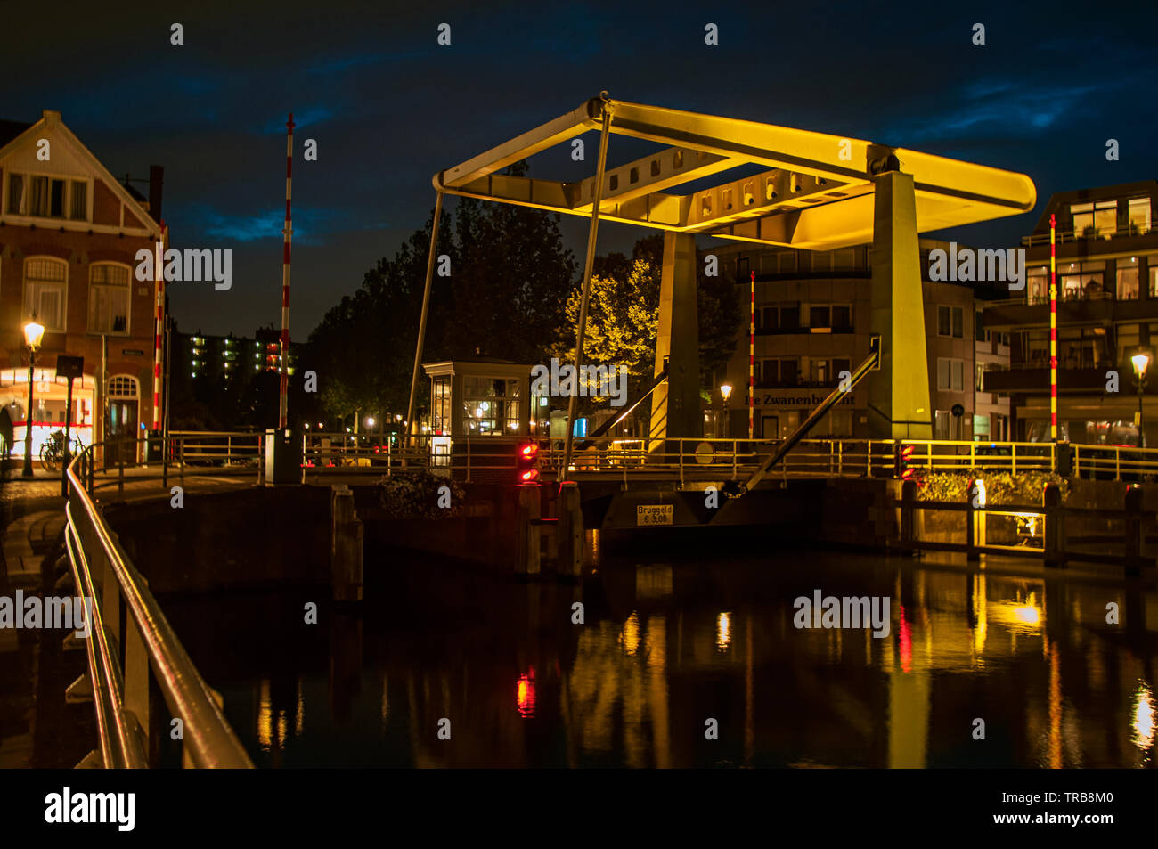Night view of wide canal with illuminated houses and bascule bridge at ...