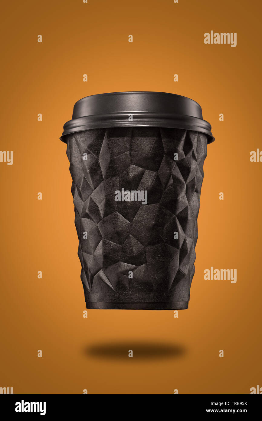 A cup of textured coffee geometry with a lid is black on a brown ...