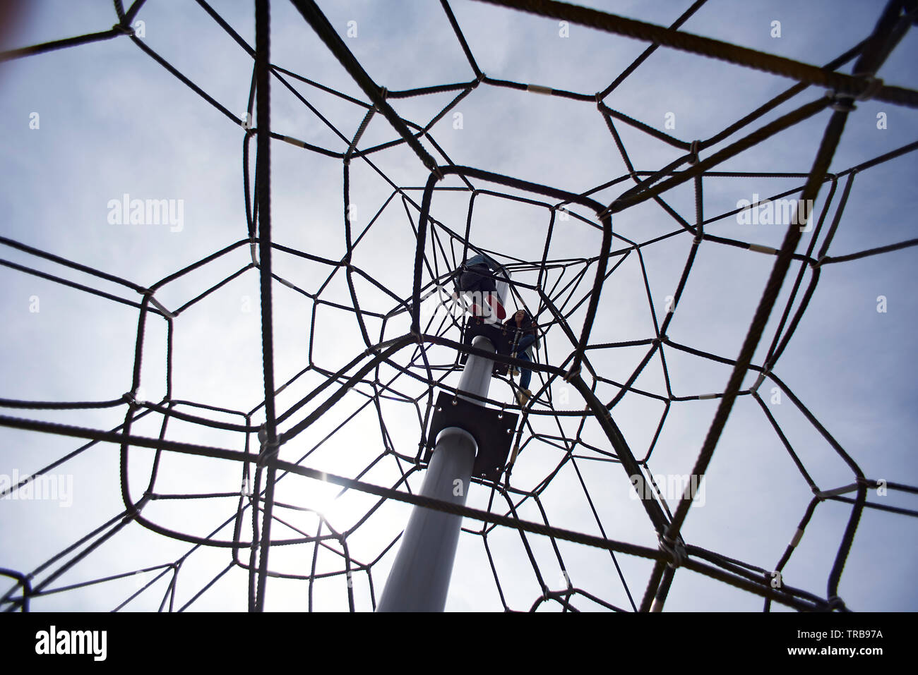 Extreme wide angle of energetic kids climbing high onto a massive ...