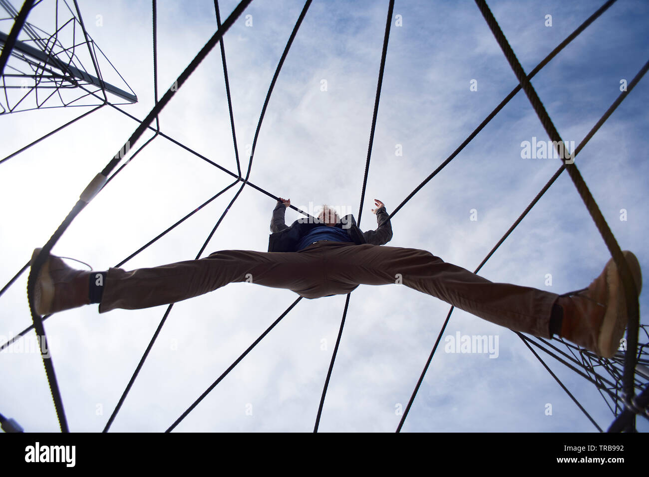 Extreme wide angle of energetic kids climbing high onto a massive ...