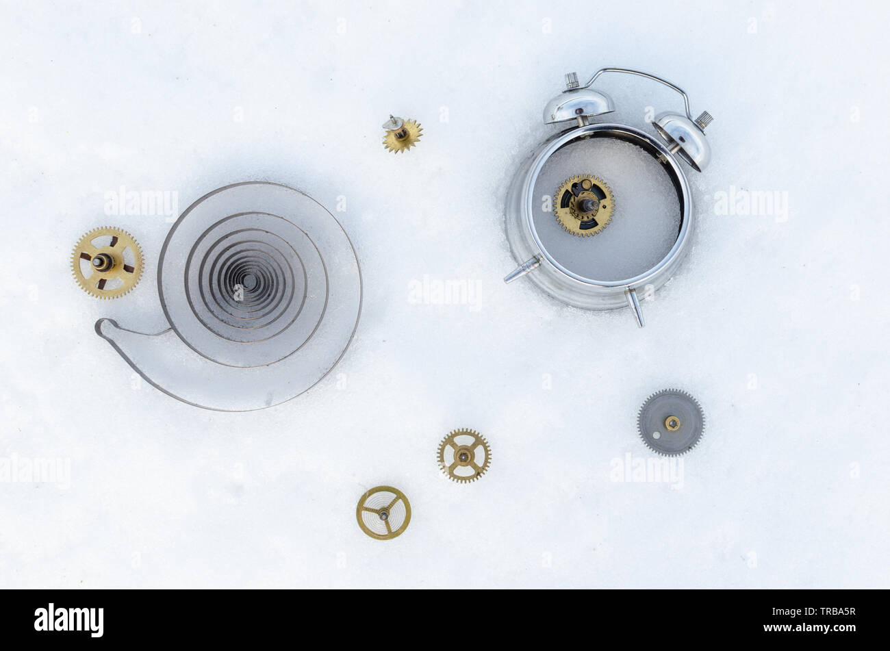 Broken clock with scattered gears on white snow Stock Photo - Alamy