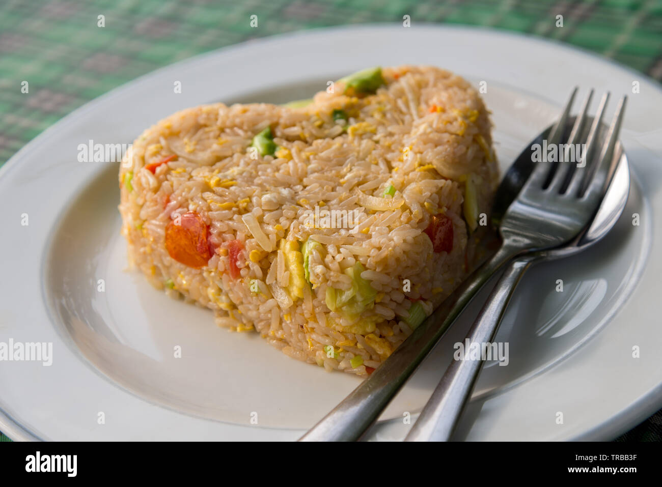 Fried rice cooked in heart shape. The plate is on a table Stock Photo ...