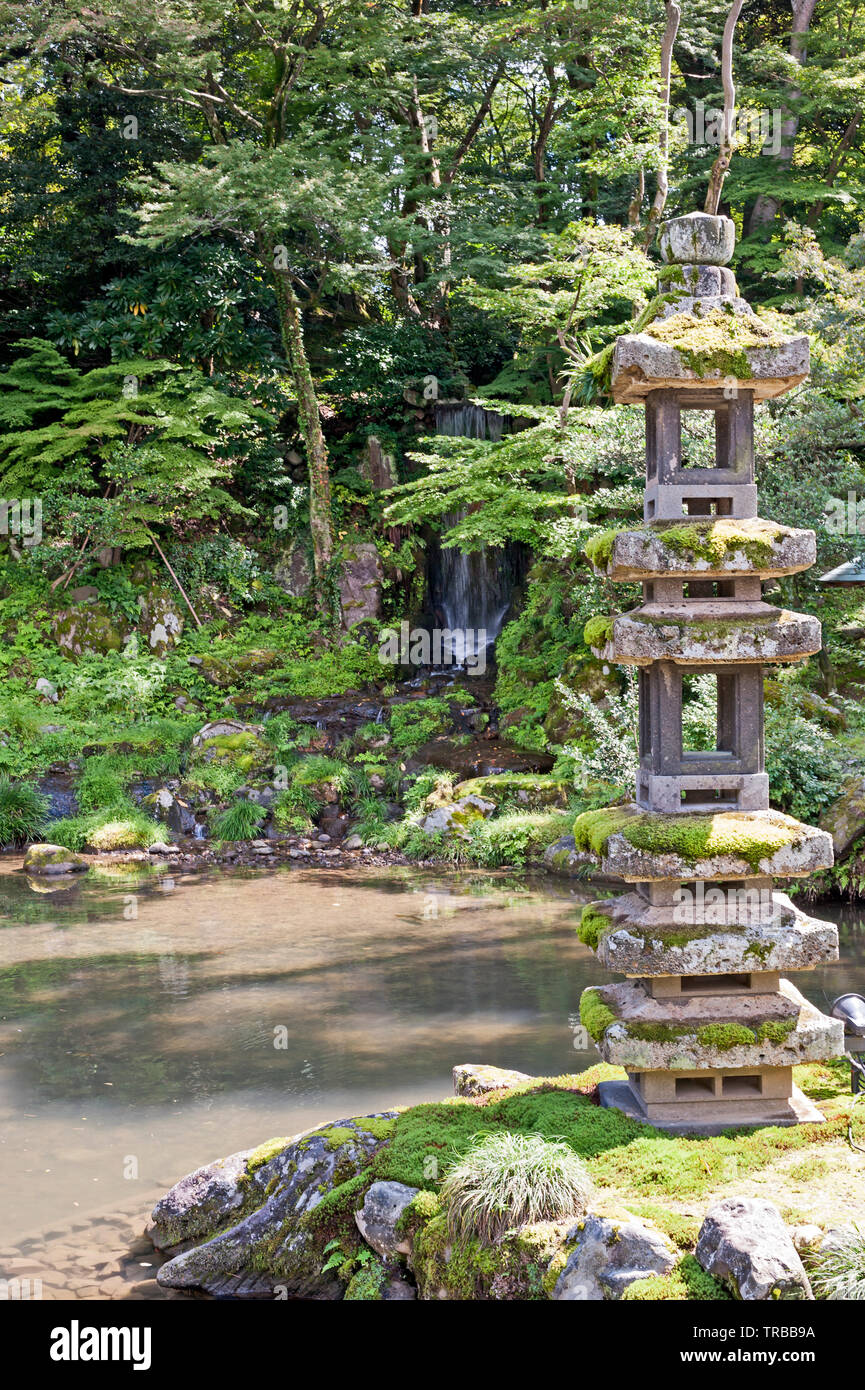 Tall Japanese lantern in foreground of Japanese garden at Kenroku-en ...