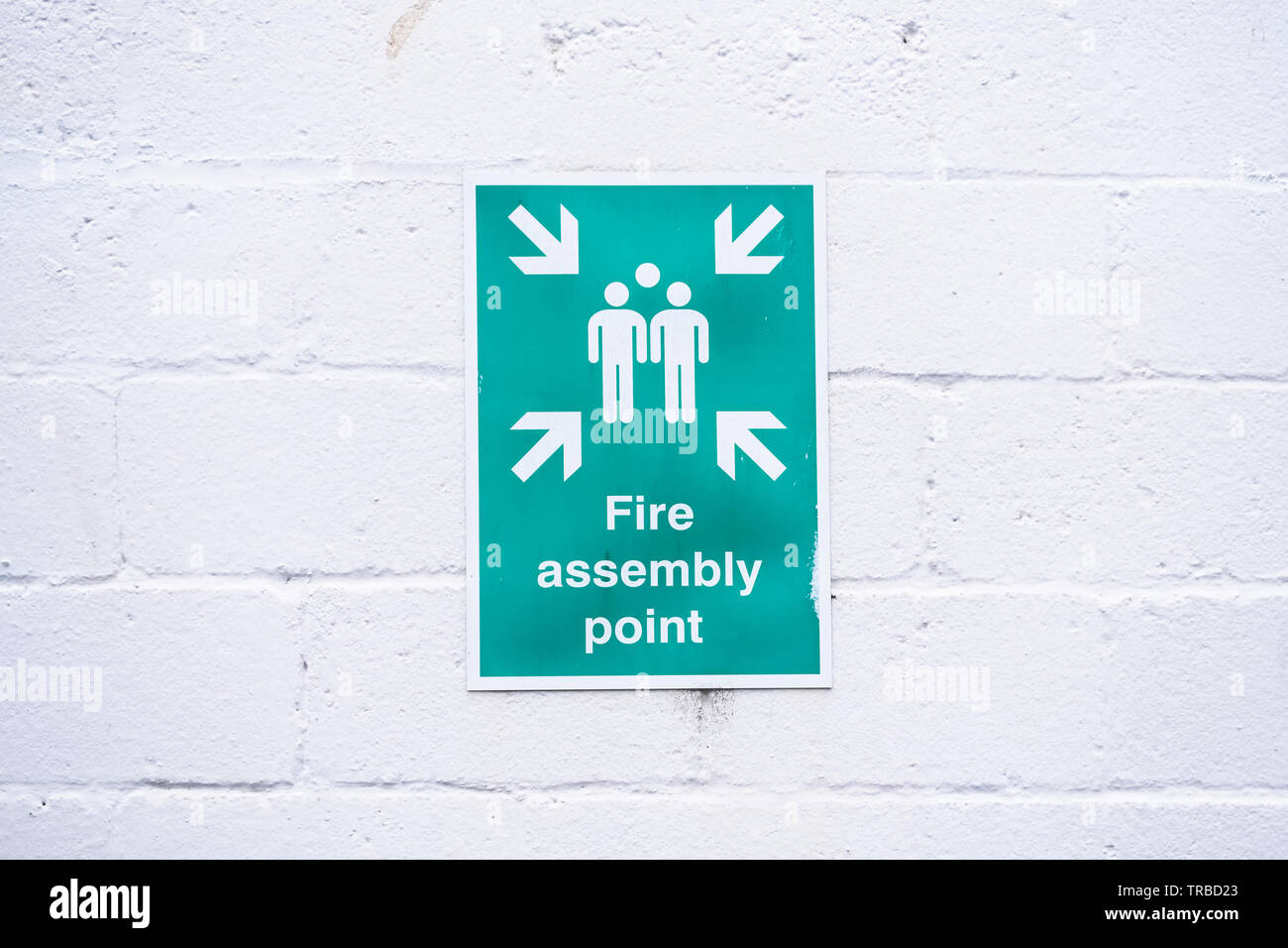 Fire assembly point sign on white wall Stock Photo - Alamy