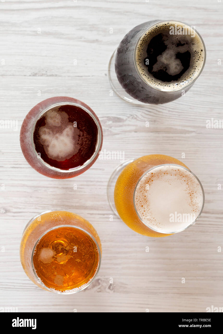 Assorted beers on a white wooden background, top view. Overhead, from ...