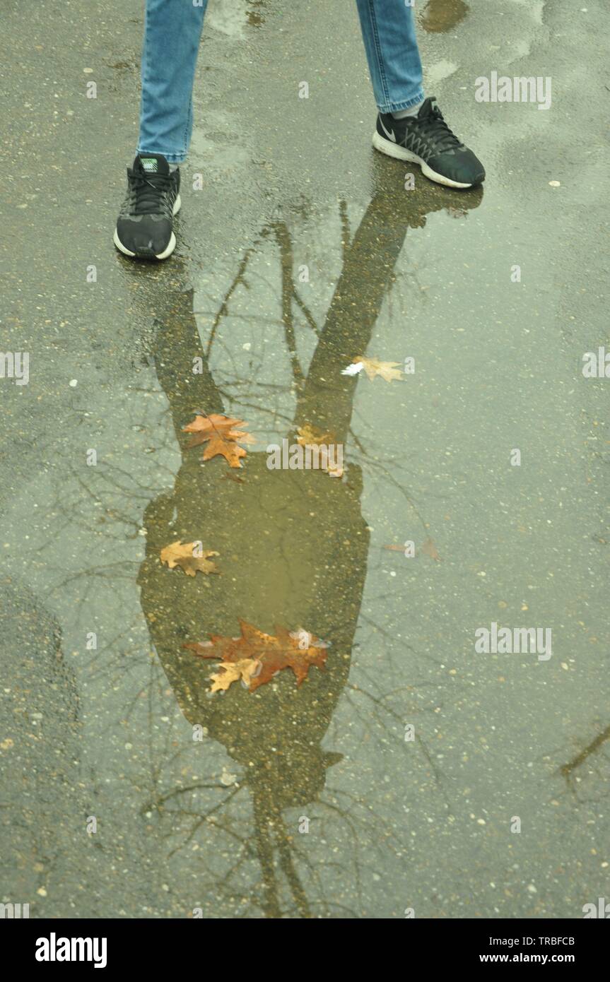 Reflection of a boy in a puddle Stock Photo - Alamy
