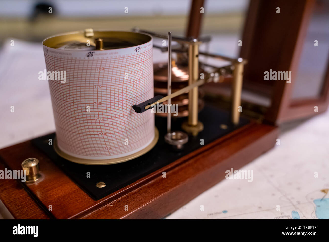 Vintage marine barograph with opened cover standing on a navigational ...