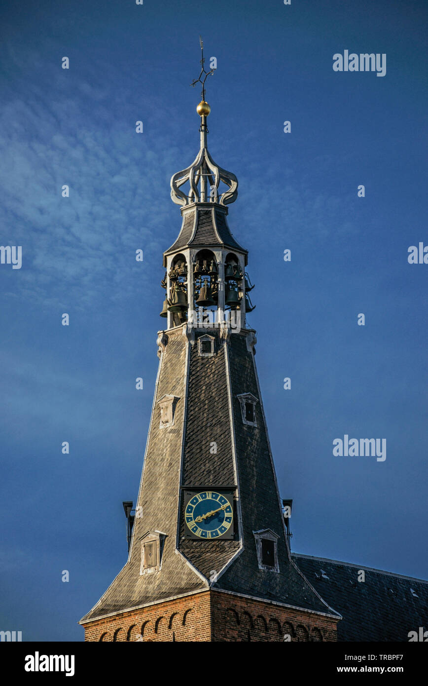 Pointed steeple roof in a church made of bricks and golden clock on ...