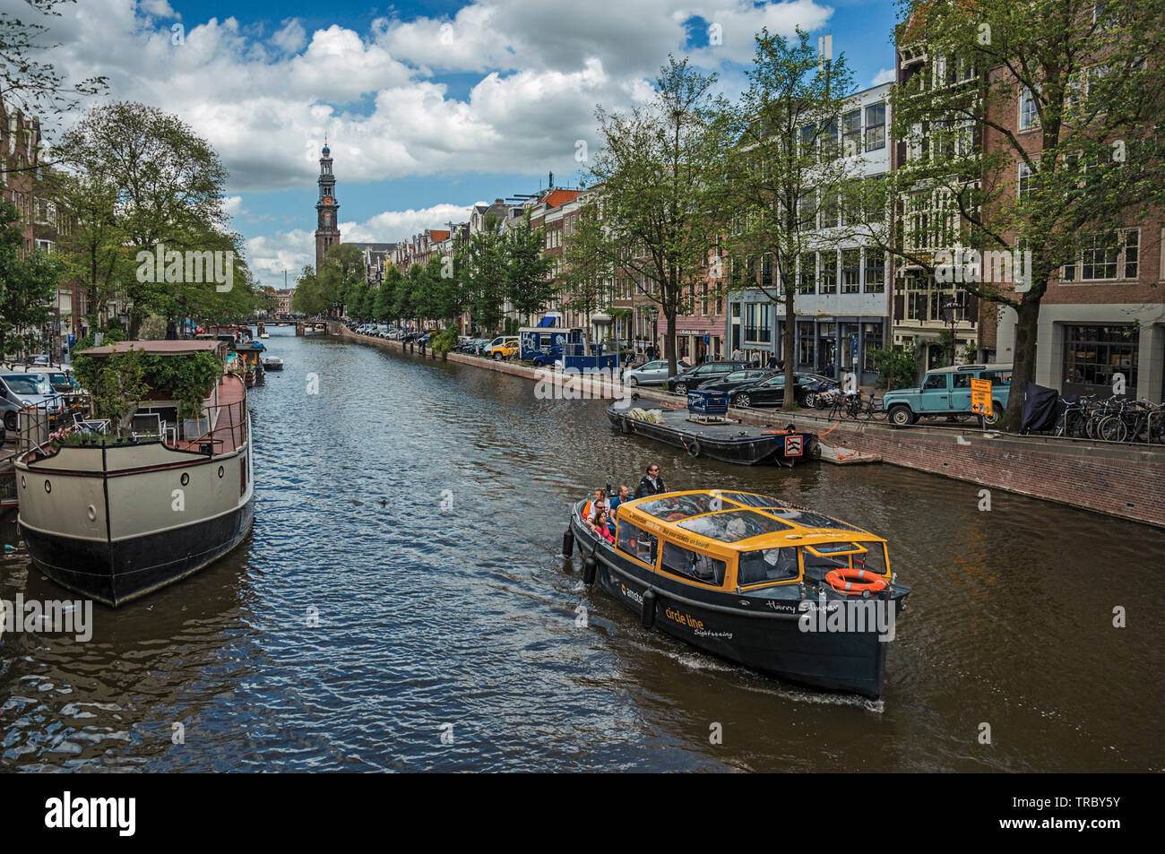 Canal with old brick buildings, boats and sunny blue sky in Amsterdam ...