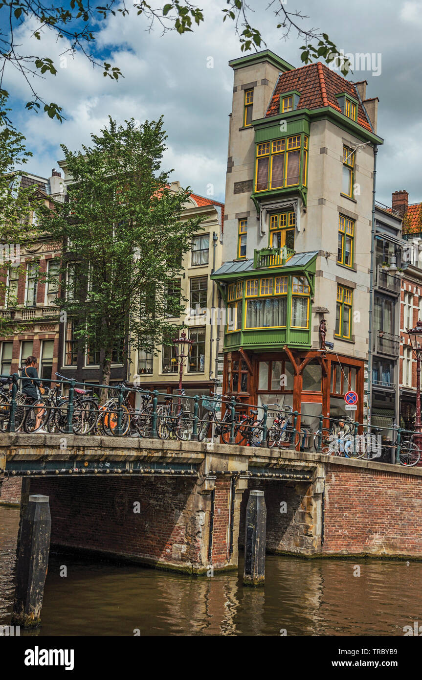 Bridge on canal with iron balustrade, bicycles and old buildings in ...