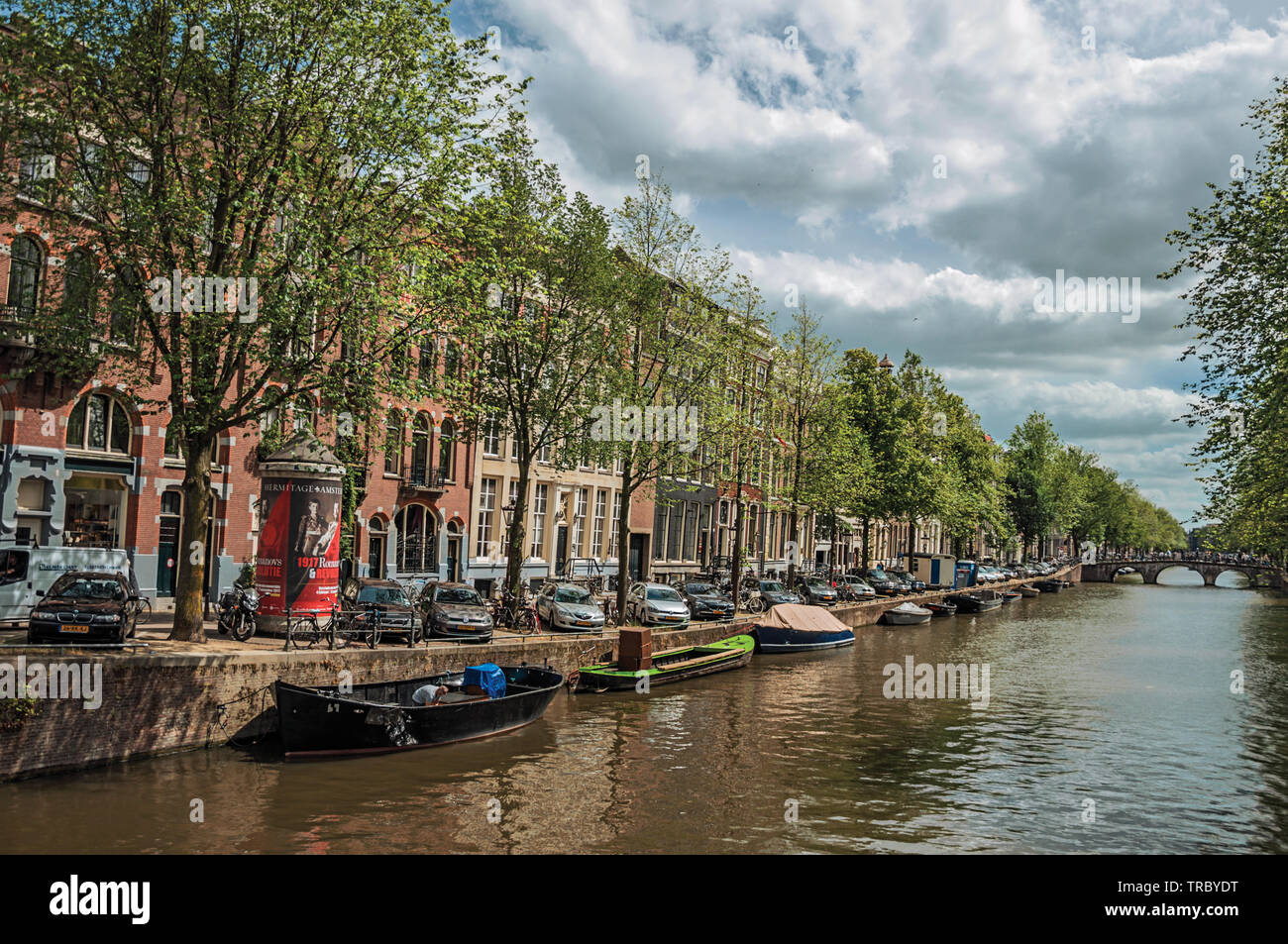 Canal with old brick buildings, bridge, boats and blue sky in Amsterdam ...