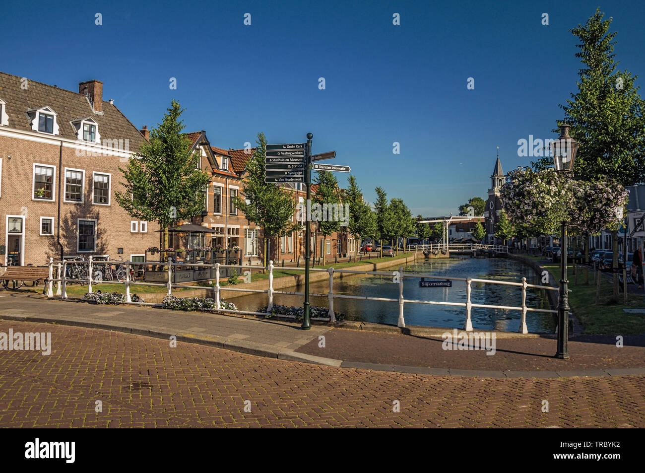 Street and bridge over the canal, brick houses and church steeple at ...