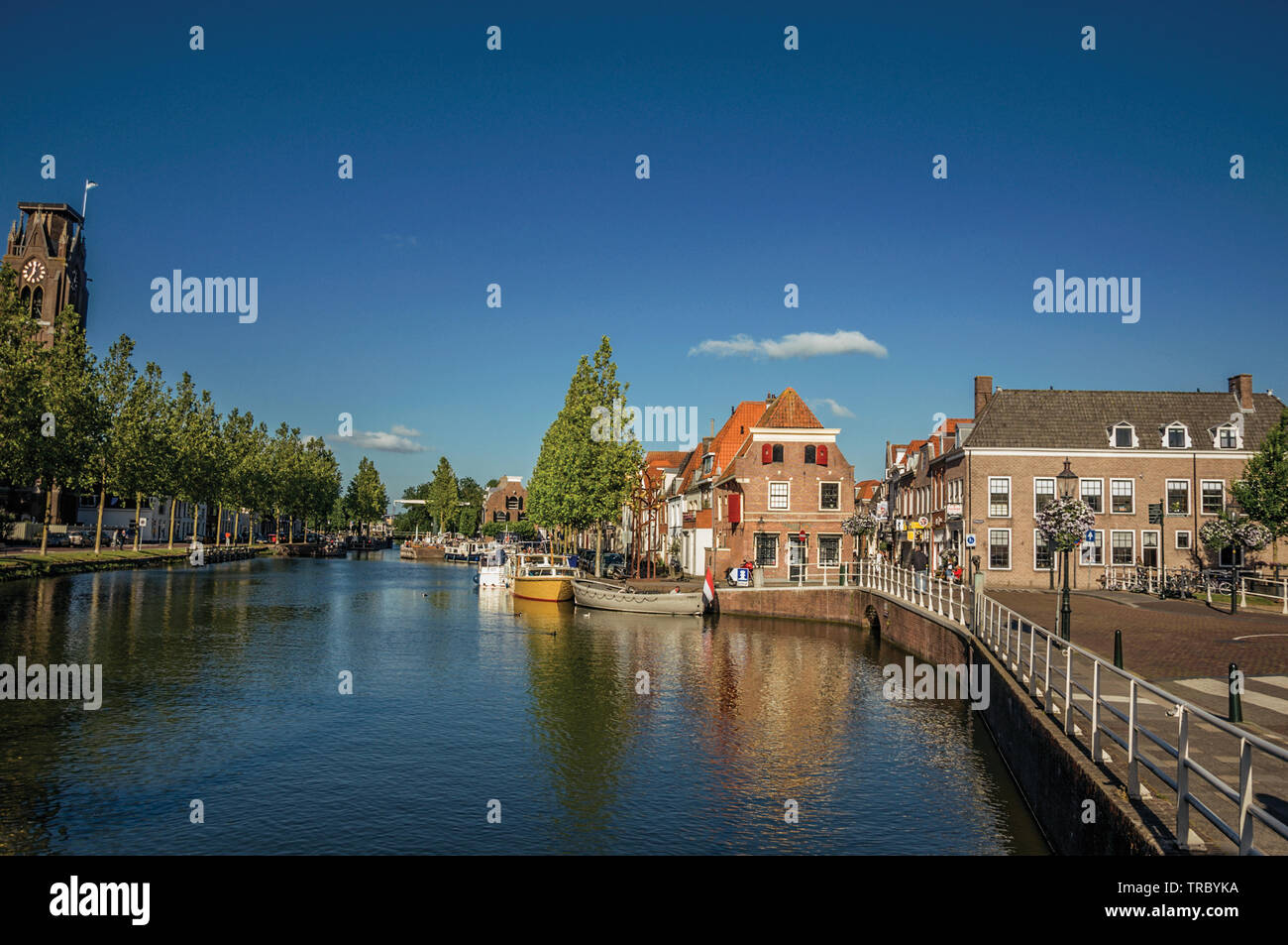 Street and bridge over the canal, moored boats and brick houses at ...